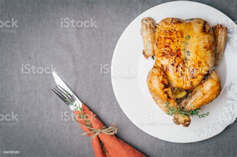 백 리 향와 구운된 닭 감자 오렌지와 회색 식탁보에 향미료 흰색 접시에 제공 됩니다 추수 감사절 이나 크리스마스 저녁 식사입니다