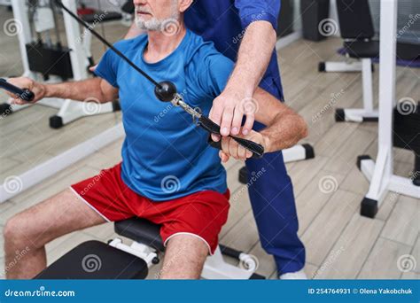 Physiotherapist Assessing Muscle Strength Of Senior Patient While