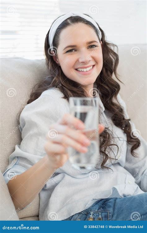 Шикарная вскользь женщина на уютном кресле держа воду Стоковое Фото изображение насчитывающей