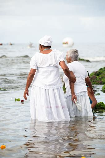Candomble 사람들은 리오 베르멜호 해변의 바위 위에서 물에 들어가 예만자에게 선물을 제공합니다 Atabaque에 대한