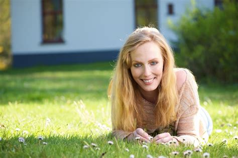 Premium Photo Portrait Of A Happy Woman Lying On Grass Outdoors