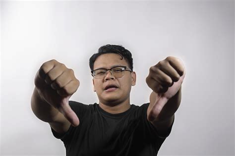 하얀 배경에 두 손으로 엄지손가락을 내리는 제스처를 보여주는 젊은 잘생긴 똑똑한 아시아 남자 20 24세에 대한 스톡 사진 및