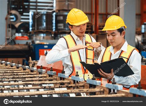 Factory Worker Operating Metal Stamping Machine While Supervised