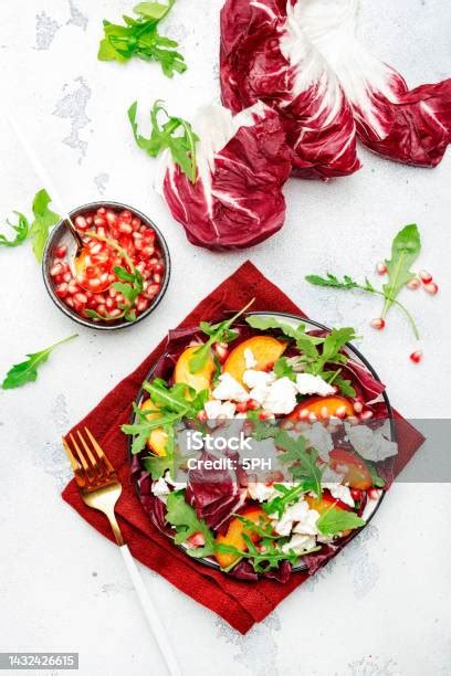 Arugula Radicchio 달콤한 복숭아 페타 치즈 및 석류 씨앗을 곁들인 신선한 샐러드 흰색 테이블 배경 위쪽 보기 0