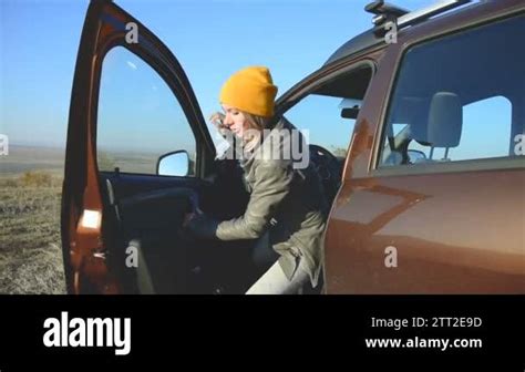 A Blonde Girl Finding A Fault In Her Suv Gets Out Of The Car And Opens The Hood Outside View