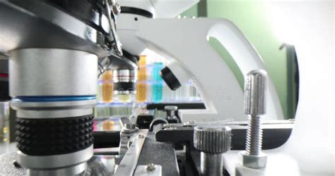 Microscope Lens In Laboratory Setting With Test Tubes Containing