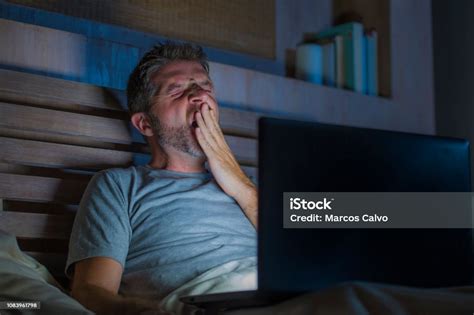 늦은 밤 지친된 침대 노트북 컴퓨터 하 품 느낌 졸려 하 고 비즈니스 프로젝트 마감 스트레스 개념에 지나치게 바쁜 작업 매력적인