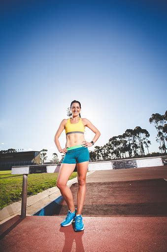 Female Fitness Model And Track Athlete Sprinting On An Athletics Track