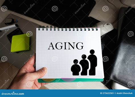 Aging Word On Notebook Holding Man Against Desktop Stock Image Image