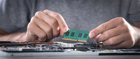 premium photo technician installing random access memory on laptop computer