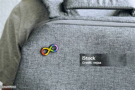 자폐증을 앓고 있는 십대 소년 인피니티 무지개 기호 기호 회색 핀 브로치 회색 배낭 세계 자폐증 인식의 날 자폐증 권리 운동 신경 다양성 자폐증 수용 운동 배낭에 대한 스톡