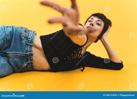 Woman Lying On Her Side On A Yellow Floor Resting Her Head On One Arm