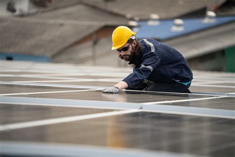 공장 옥상에 설치된 전자기기로 태양전지나 태양전지를 점검하는 남성 엔지니어 기술자 작업자가 시스템을 수리하거나 검사합니다 산업용 재생 에너지 개념 건설 산업에 대한 스톡