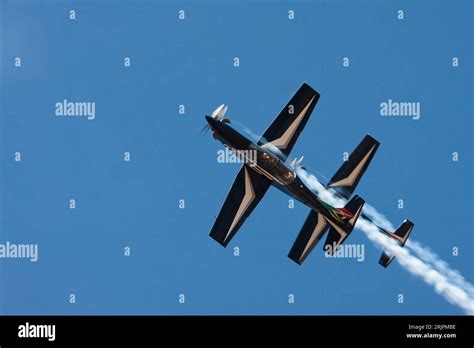 A small airplane is performing aerobatics in the sky, leaving a ...