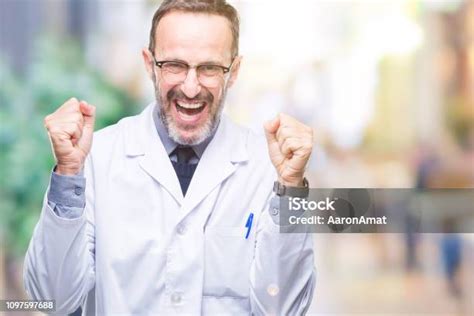 중 년 수석 노인의 전문 남자 축 하 하는 고립 된 배경 위에 착용 백색 외 투는 놀라게 하 고 무기와 성공을 위한 깜짝 놀라게 제기 하 고 눈 우승자 개념입니다 과학자에