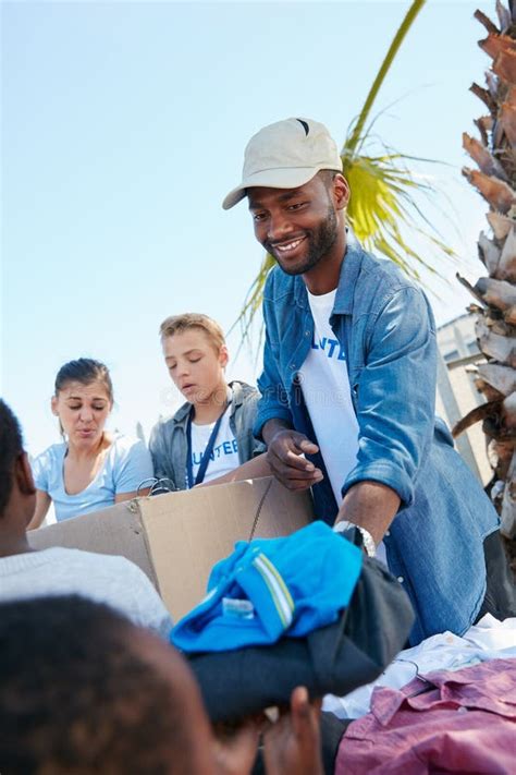 This Ones For You Little Man Volunteer Workers Handing Out Clothing To