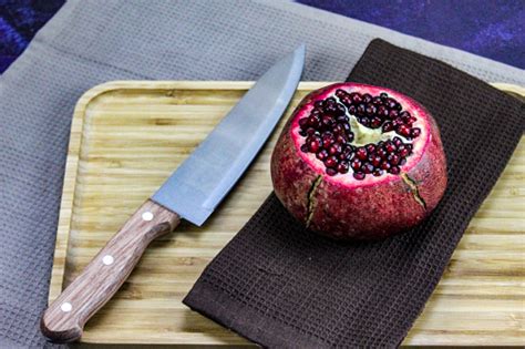 파란색 배경에 나무 트레이에 냅킨 천에 전체 석류 플래터의 상단을 잘라 그 옆에 칼을 가진 커다란 붉은 잘 익은 석류 건강한 삶의 개념 과일 0명에 대한 스톡 사진 및 기타