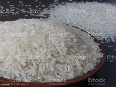 검은 색 배경에 나무 접시에 원시 흰 쌀의 가까이 쌀은 아시아인의 주요 음식이며 중국 전통 요리의 재료입니다 0명에 대한 스톡