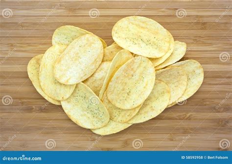 Картофельные стружки на разделочной доске Стоковое Фото изображение насчитывающей верх желтый