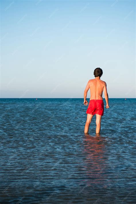 Premium Photo Rear View Of Shirtless Man Standing In Sea