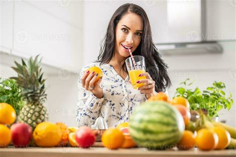 Girl Sips A Freshly Squeezed Orange Juice With A Paper Straw Surrounded