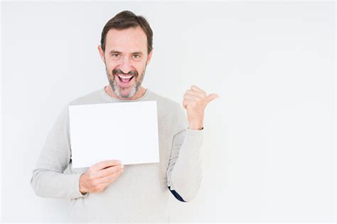 고 행복 얼굴 미소와 측면까지 손가락으로 보여주는 격리 된 배경 위에 빈 종이 시트를 보유 하는 수석 남자 가리키기에 대한 스톡