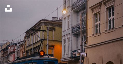 낮 동안 흰색 콘크리트 건물 근처 도로에서 노란색과 파란색 버스 사진 Unsplash의 무료 도시 이미지