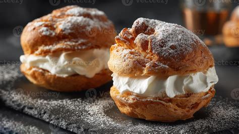 Cream Puffs With Powdered Sugar Are Displayed On A Dark Serving Tray