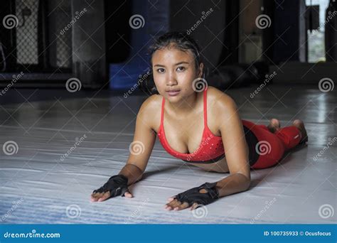 Young Beautiful Sweaty Asian Woman In Sport Clothes Stretching On Gym
