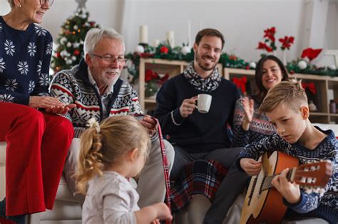 크리스마스에 다세대 가족을 위해 어쿠스틱 기타를 연주하는 십대 소년 10 11세에 대한 스톡 사진 및 기타 이미지 10 11