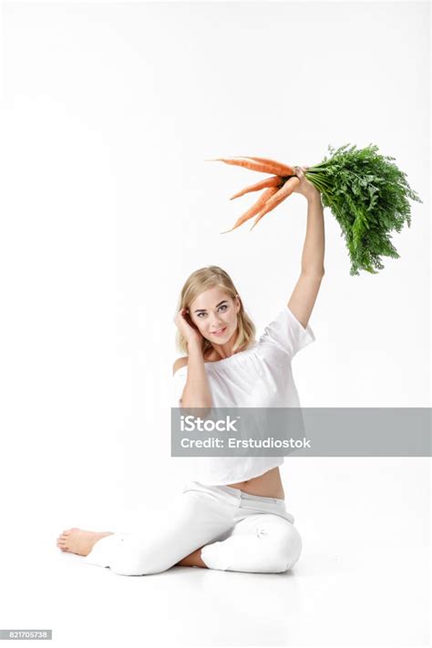 아름 다운 금발의 여 자가 녹색 신선한 당근 들고 흰색 바탕에 나뭇잎 건강 및 다이어트 미소에 대한 스톡 사진 및 기타 이미지 미소 건강한 생활방식 건강한 식생활