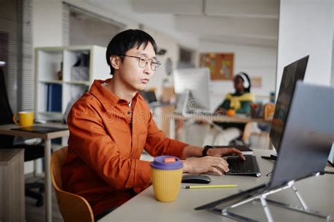 Working Asian Man Using Laptop In Modern Office Setting Stock Image Image Of Software