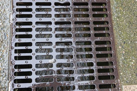 도시의 콘크리트 보도에 설치된 금속 배수 덮개에 물이 고입니다 0명에 대한 스톡 사진 및 기타 이미지 0명 강철 거리 Istock