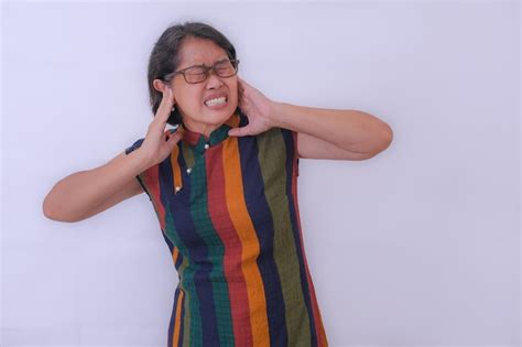Premium Photo A Middleaged Woman Covers Her Ears With Her Hands While
