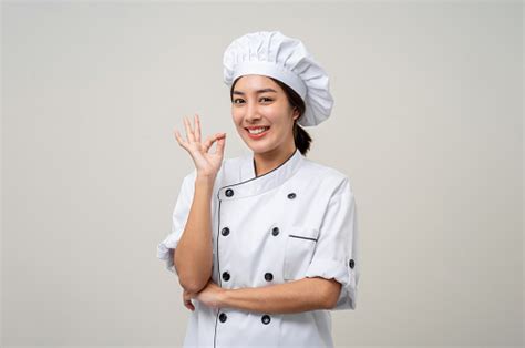제복을 입은 젊은 아름다운 아시아 여성 요리사가 고립된 배경에 맛있는 손짓을 하고 있다 요리 여자 직업 요리사 또는 제빵사 부엌
