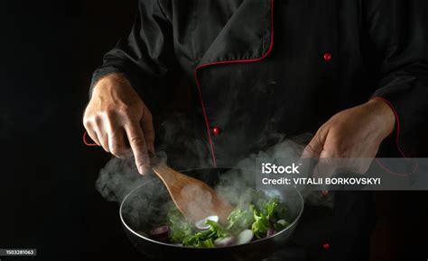 전문 요리사가 프라이팬에 야채를 준비합니다 어두운 배경에 건강한 채식 음식과 식사를 요리하는 개념 무료 광고 공간 건강한 생활