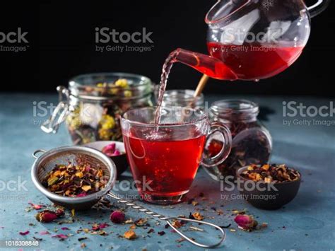 프로세스 양조 차 다도 갓 내린된 신선한 과일 및 허브 차 어두운 분위기의 컵 뜨거운 물 주전자에서 찻 잎을 한잔에 붓고 있습니다 차 뜨거운 음료에 대한 스톡 사진 및 기타