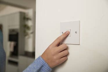 Finger Of Girl Turning Off Switch At Home Stock Photo