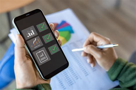 모바일 스마트 폰을 사용하여 재무 세무 회계 통계 및 분석 연구 개념을 계산하기 위해 회계 대차 대조표를 다루는 비즈니스 여성 Brand Name Smart Phone에