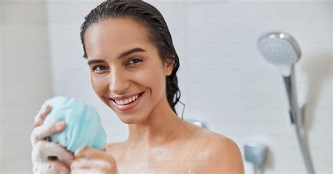 Beautiful Lady With Bath Washcloth In Her Hands Looking At Camera And Smiling While Taking