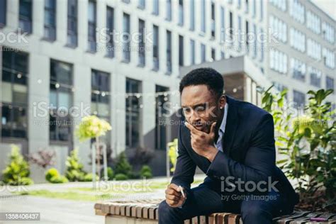 도시 거리 배경에 도시 공원 벤치에 앉아 야외에서 대마초를 흡연 아프리카 계 미국인 사업가 남성 직원 사업가 양복을 입은 사무실