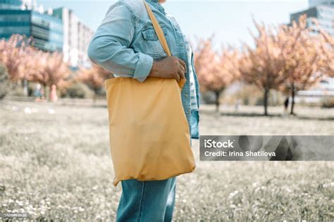 여자는 모형 빈 템플릿을 위해 토트 백 캔버스 직물을 들고있다 토트백에 대한 스톡 사진 및 기타 이미지 토트백 여자 지갑