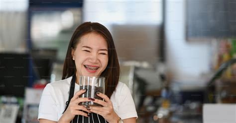 커피숍에서 갓 볶은 커피 원두가 담긴 유리 그릇을 들고 있는 행복한 아시아 바리스타 여성 사진 Unsplash의 사업 이미지