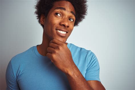 아프리카계 미국인 남자 와 아프리카 계 미국인 남자 와 Afro 머리 입고 푸른 티셔츠 위에 서 고립 된 흰색 배경 심각한 얼굴