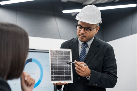 비즈니스 팀 회의는 혁신적이고 효율적인 태양 전지 패널 배터리에 대한 재생 가능 에너지에 대해 논의합니다 태양열 발전기 전력 청정 에너지 전기 생성 2명에 대한 스톡 사진