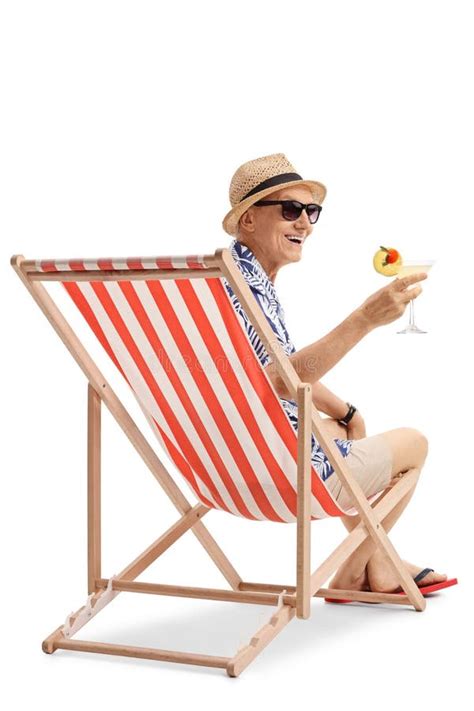 Happy Elderly Tourist With A Cocktail Sitting In A Deck Chair Stock