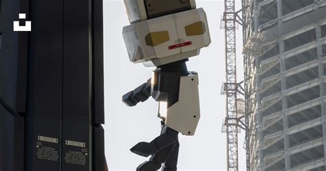 A Robot Hanging From The Side Of A Tall Building Photo Free Tower