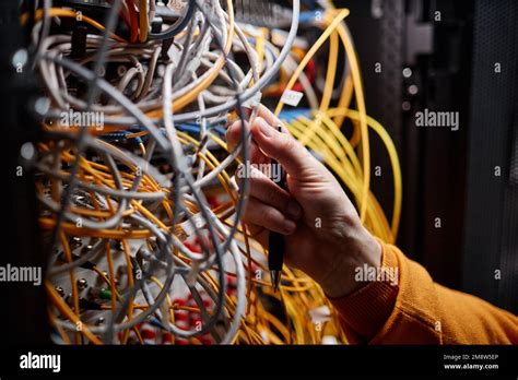Close Up Of Technician Connecting Cables And Wires In Server Cabinet