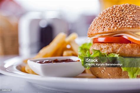 참깨 롤빵 양상추 고기 커틀릿 토마토 치즈를 튀김과 소스가 들어간 흰색 둥근 접시에 곁들인 햄버거 수평 방향 가루로 빻은에 대한 스톡 사진 및 기타 이미지 Istock