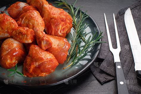 腌过的鸡腿放在蓝色盘子上以灰色背景腌过生鸡肉腌肉烤腿